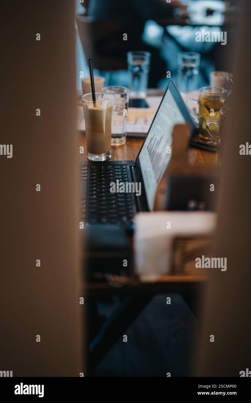 Open laptop with iced coffee and tea in a cozy café setting Stock Photo ...