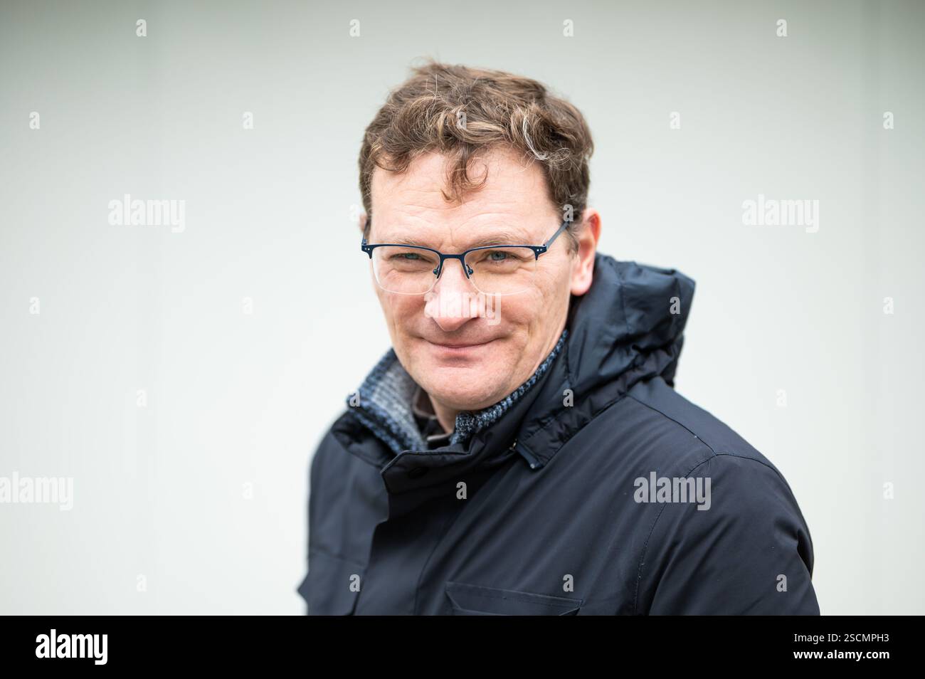 Portrait of a 45 yo white male wearing a dark winter jacket against a ...
