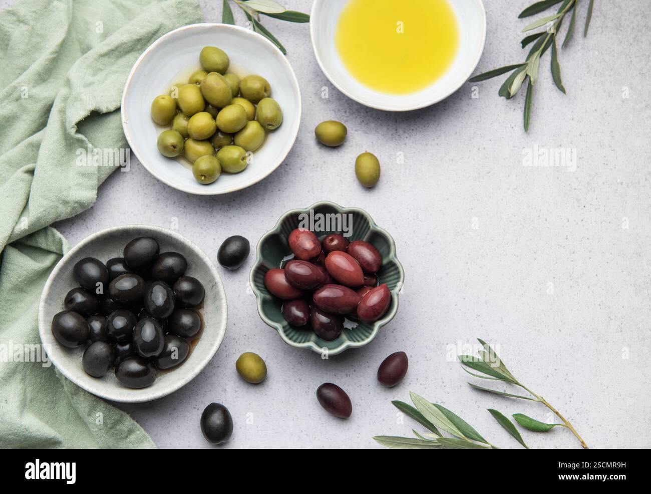 Variety of marinated olives with olive oil and olive tree branches ...