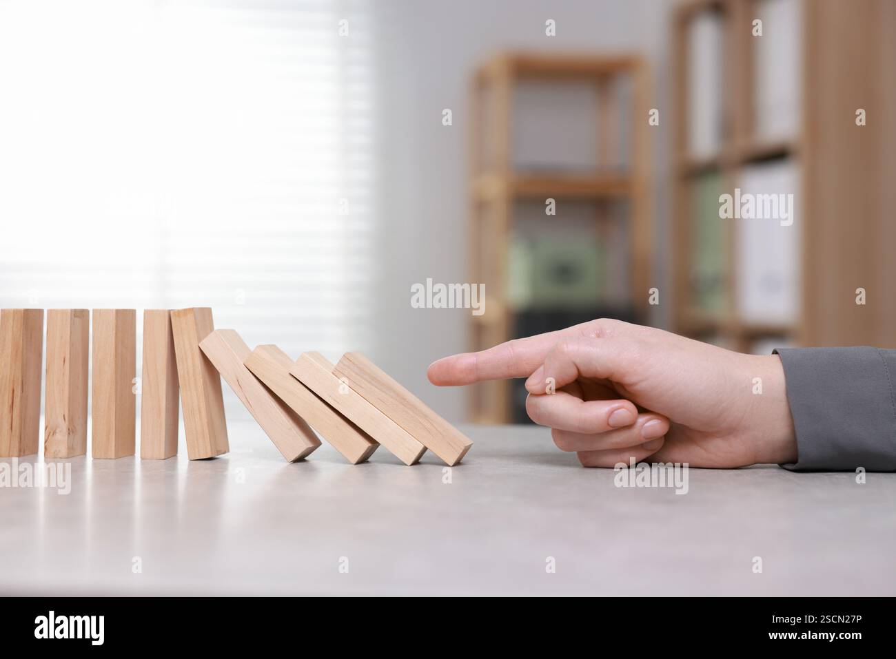 Domino effect. Woman pushing wooden blocks at table, closeup Stock ...