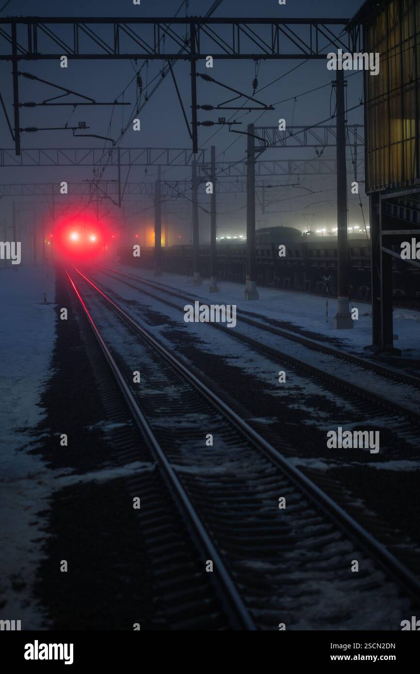 Empty railway and railroad traffic lights with red signal in fog at ...