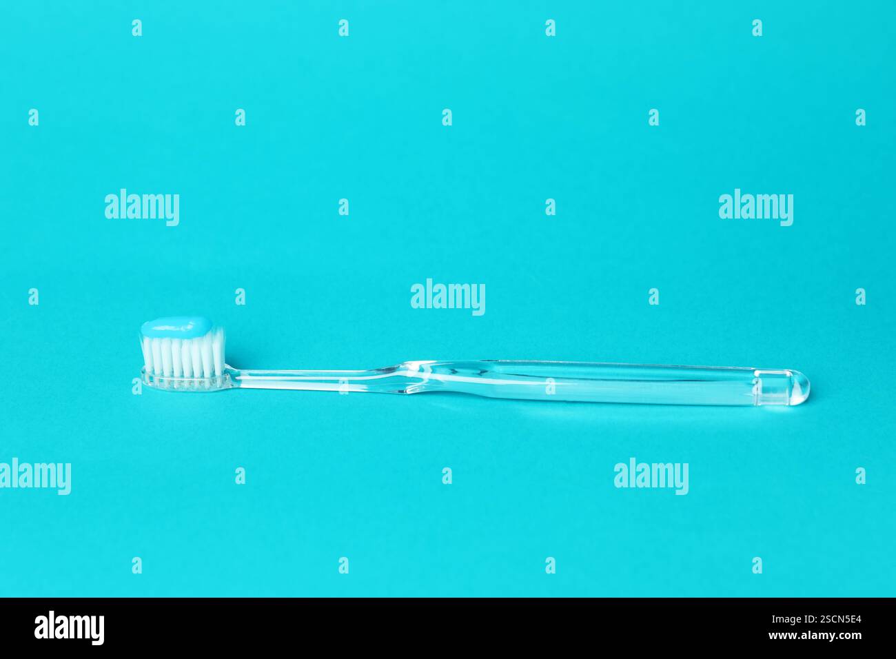 Toothbrush with toothpaste in air on light blue background Stock Photo ...