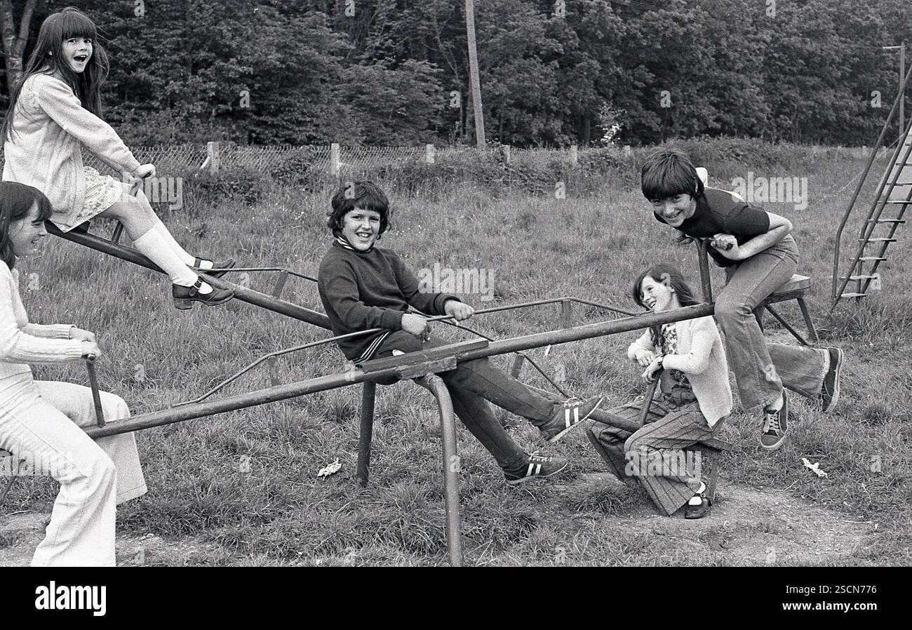 1970, outside in a field, some boys and girls having fun together ...