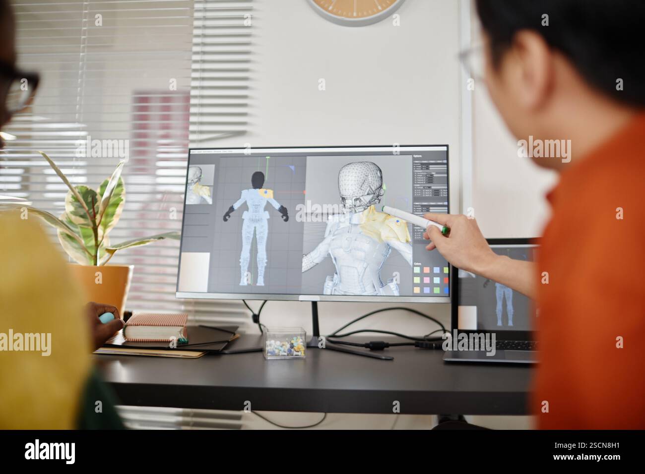 Two people observing and working on the design of robot displayed on ...