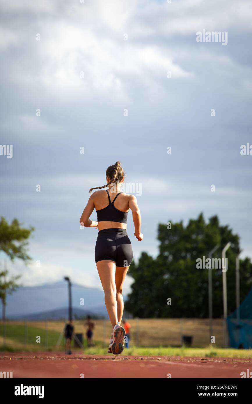 Female athlete in black sportswear training on a professional running ...