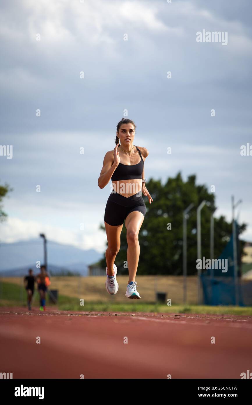 Female athlete in black sportswear training on a professional running ...