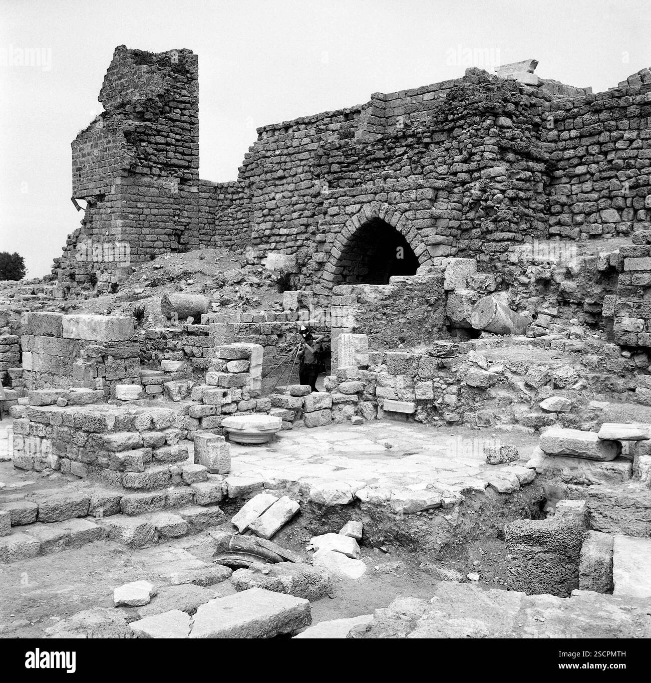 A photographer with a tripod stands amidst the ruins of the Roman site ...