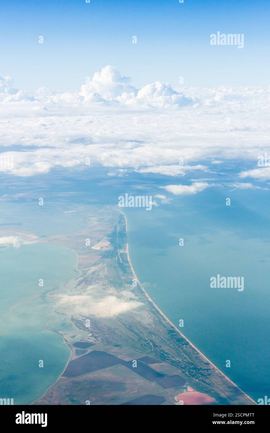 Coastal landscape showcasing a long sandy inlet under a clear sky with ...