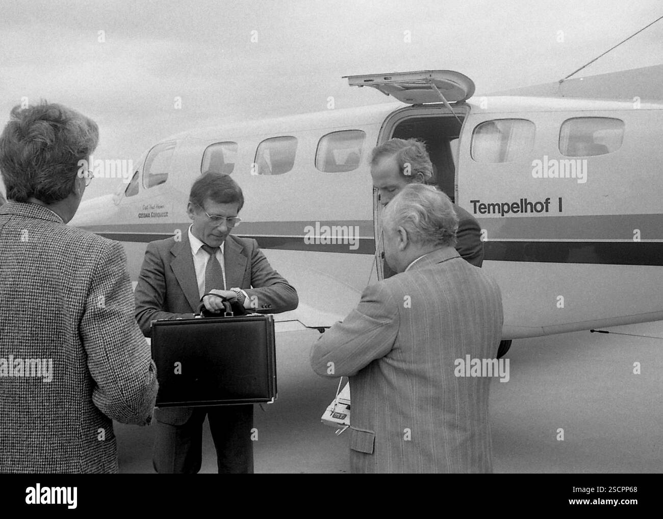 Men in conversation before their flight from Berlin to Cologne in an ...