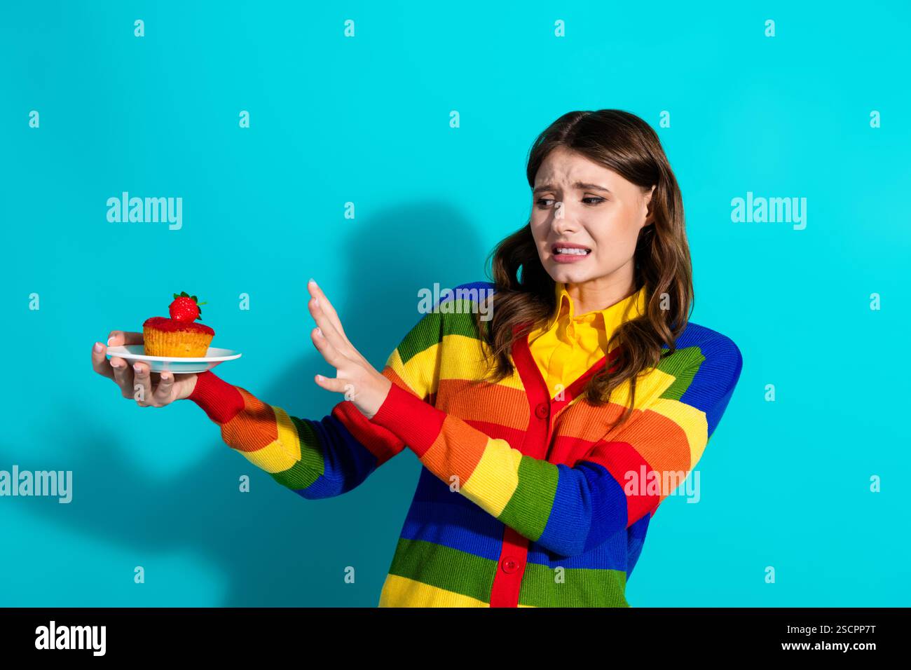 Young woman in a colorful rainbow sweater showing an expressive ...