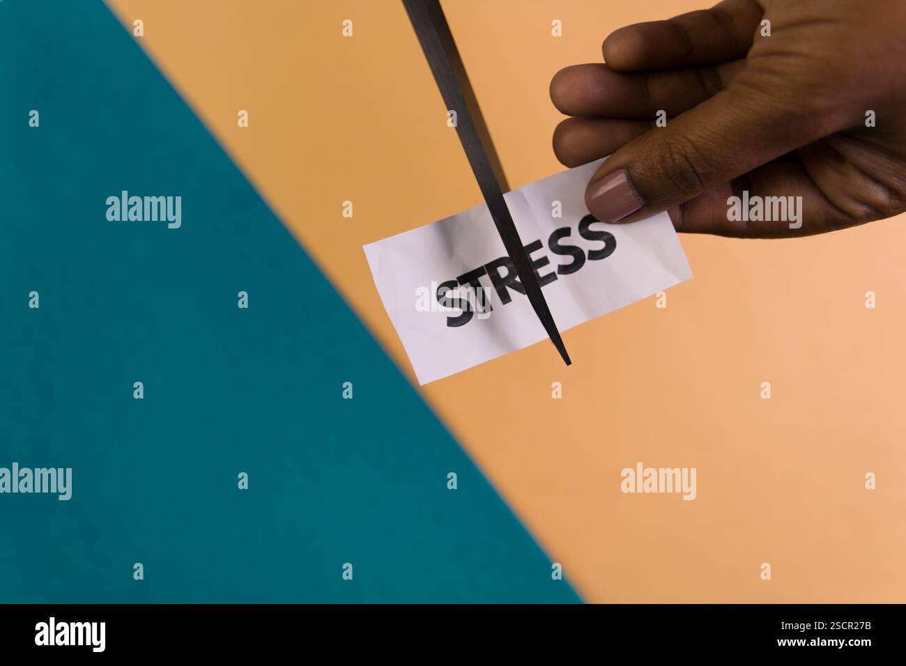 A hand using scissors to cut a card labeled stress on a colorful ...