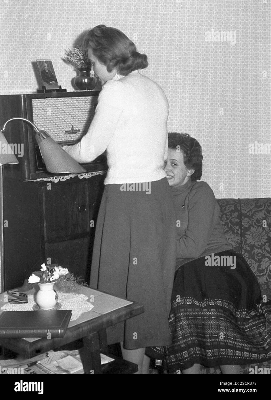 Two women operating a radio set. GDR, 1956. [automated translation ...