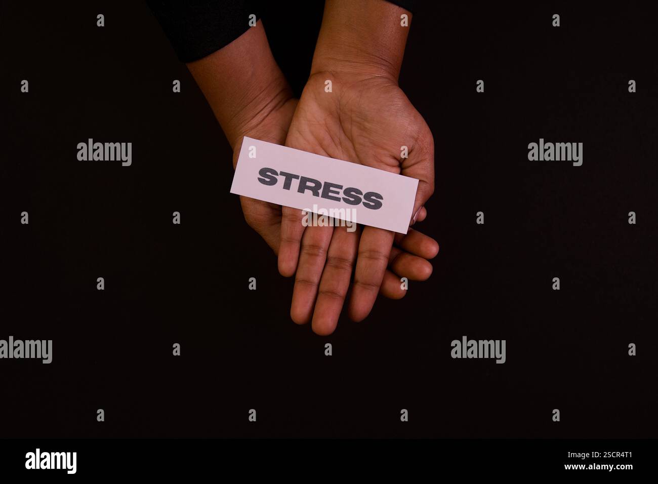 Hands holding a card with the word stress, reflecting anxiety and ...