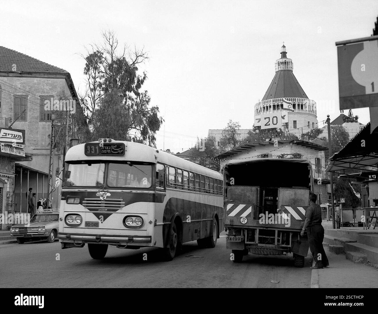 A street in Nazareth with a bus and a truck on the road. The Church of ...