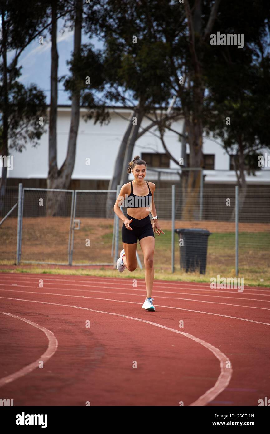 Female athlete in black sportswear training on a professional running ...