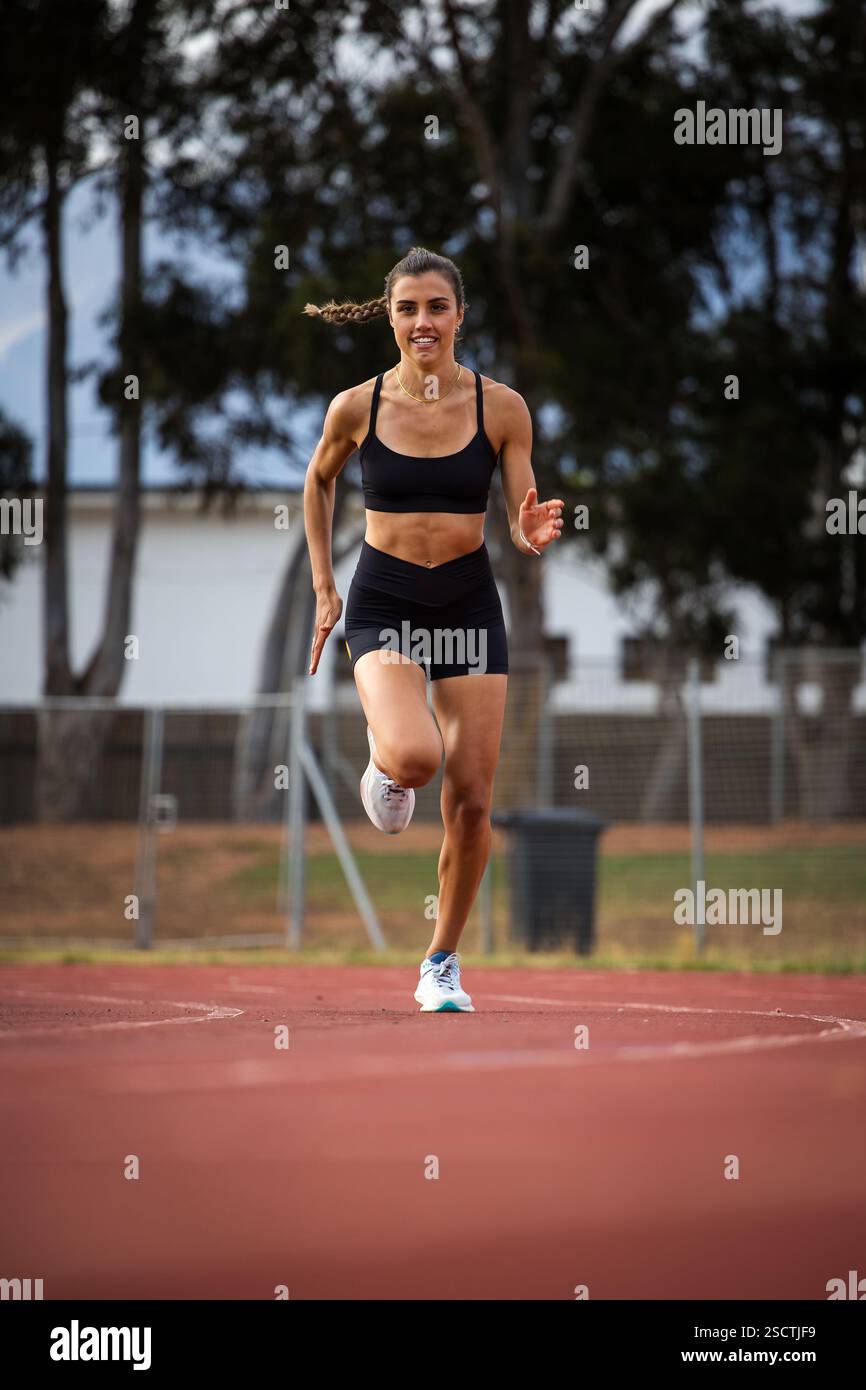 Female athlete in black sportswear training on a professional running ...