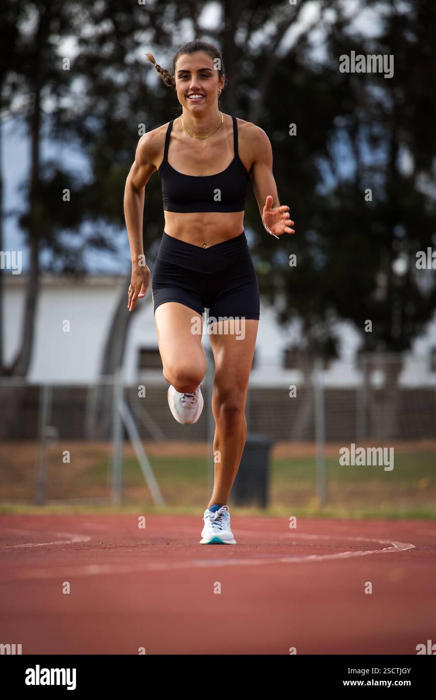 Female athlete in black sportswear training on a professional running ...