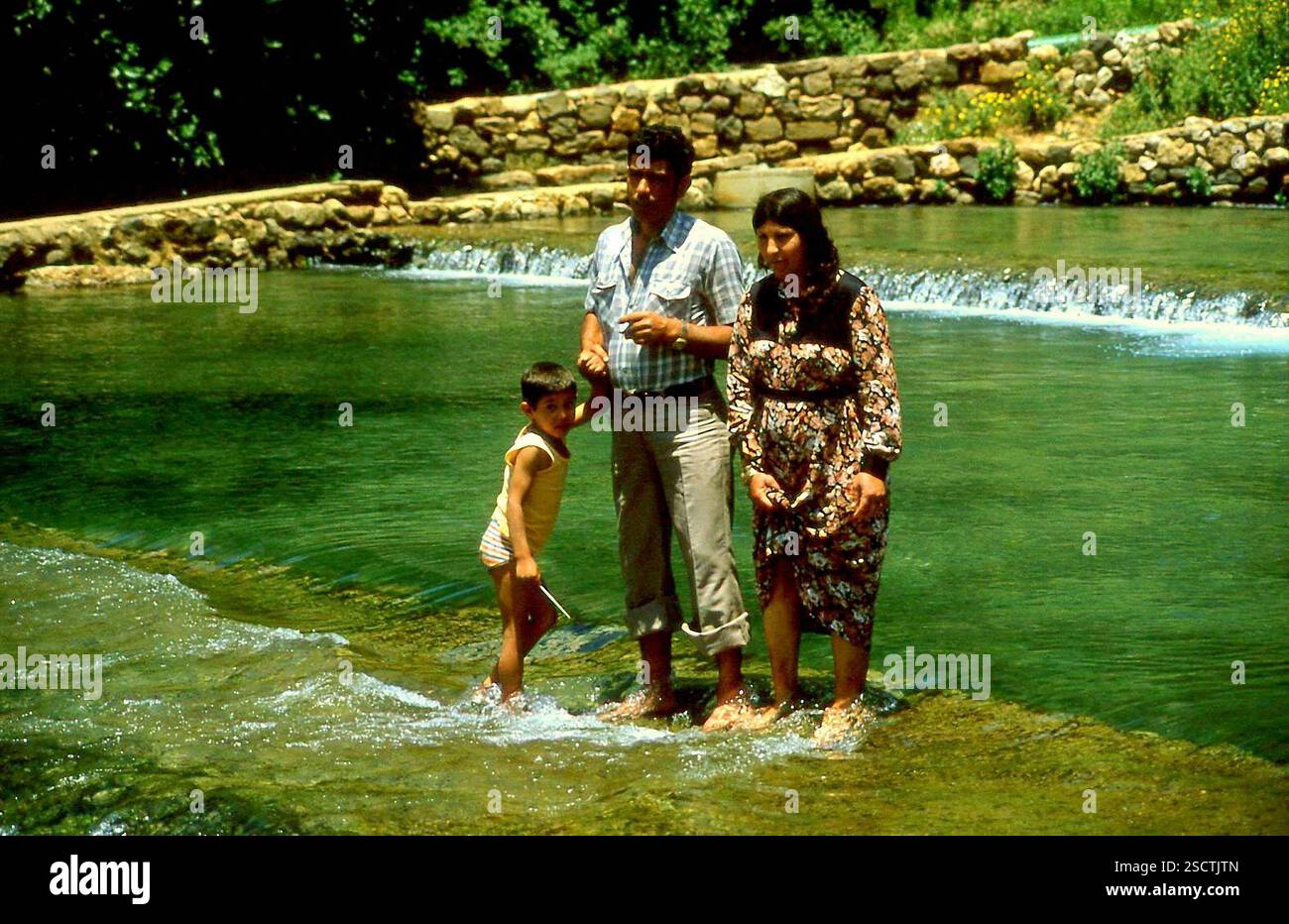 A family crosses the Banyas River, also known as the Hermon River ...