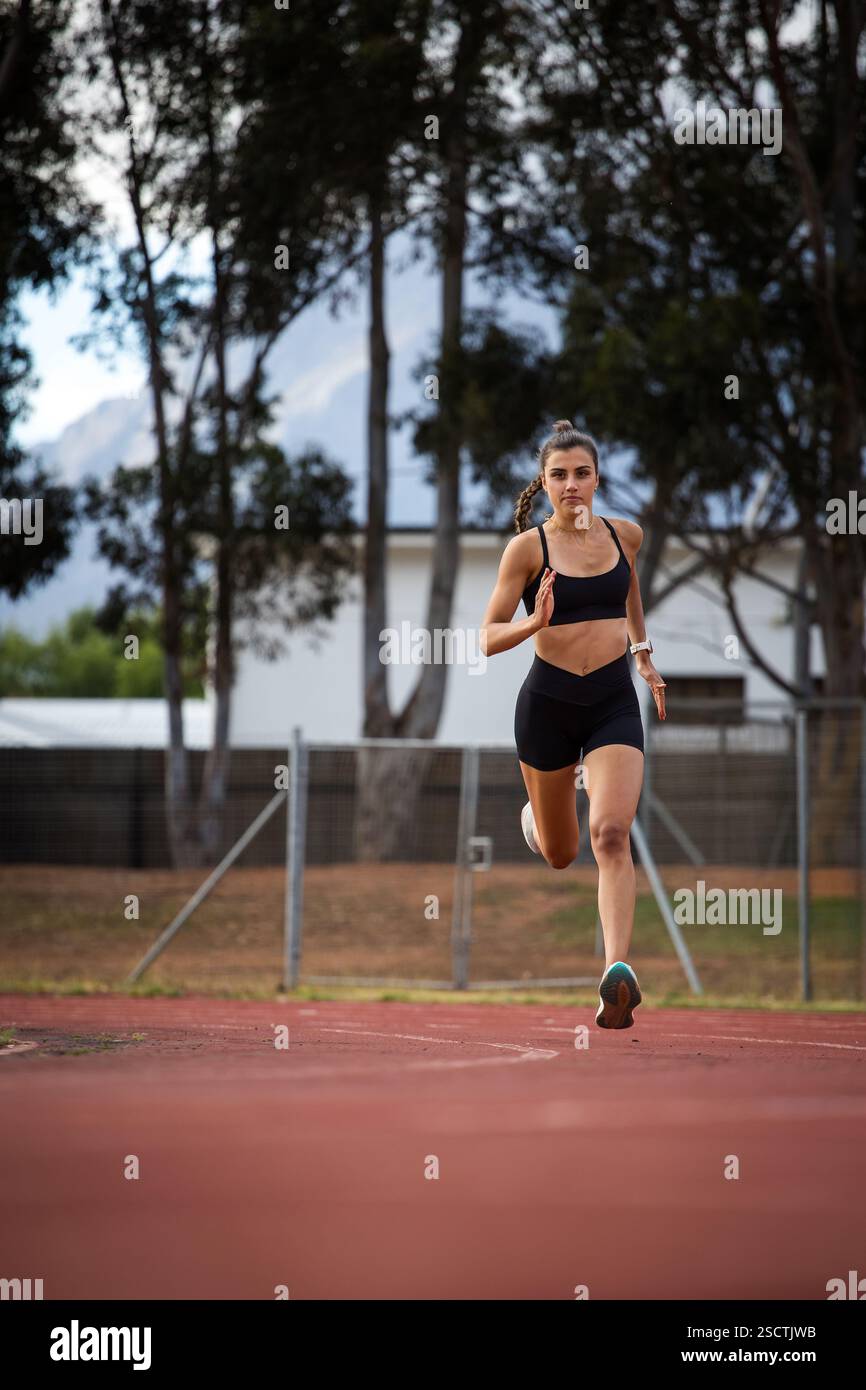 Female athlete in black sportswear training on a professional running ...