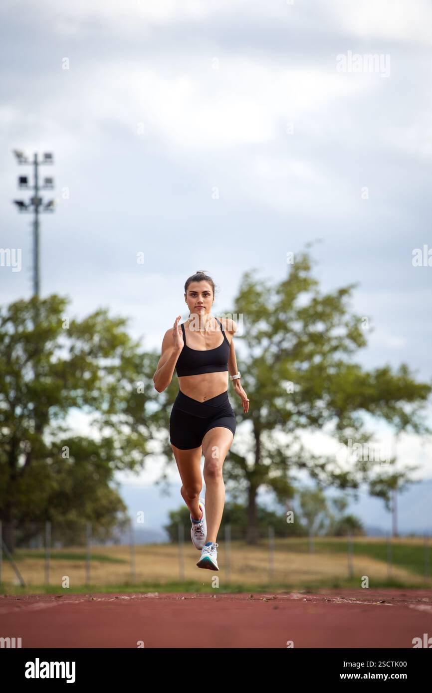 Female athlete in black sportswear training on a professional running ...