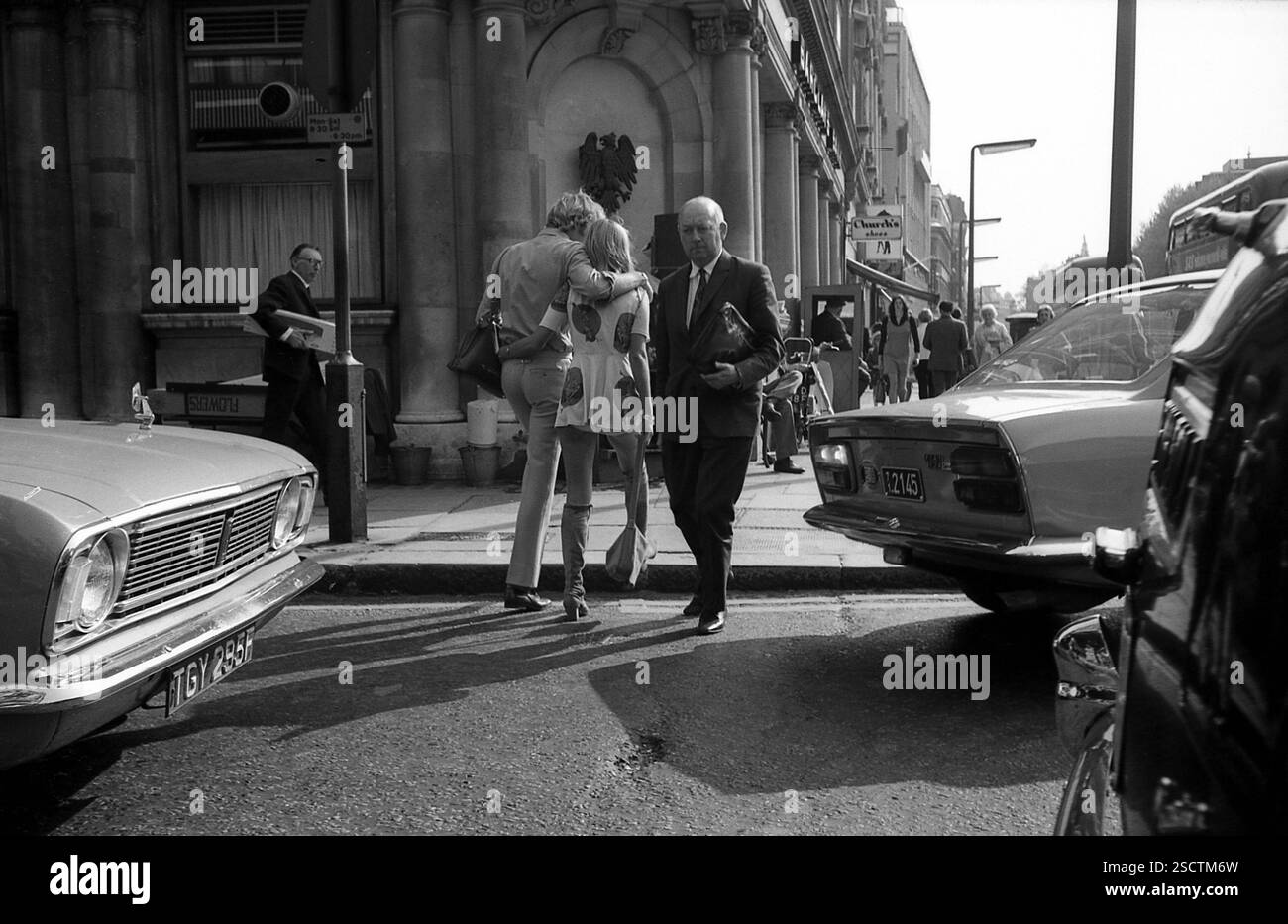 Knightsbridge London: Man with briefcase and couple crossing the road ...