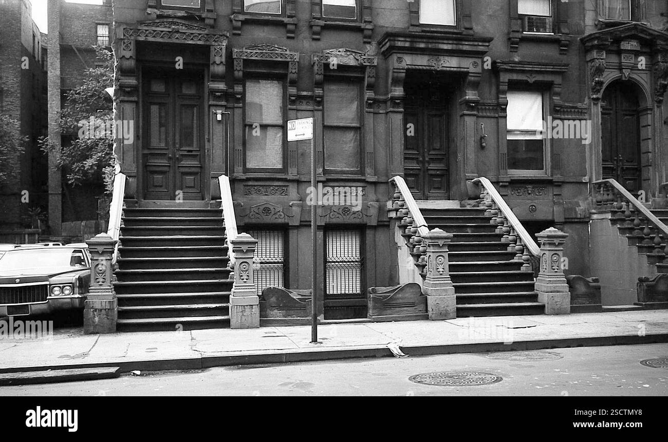 Railings and steps in front of houses and a car on the left in ...