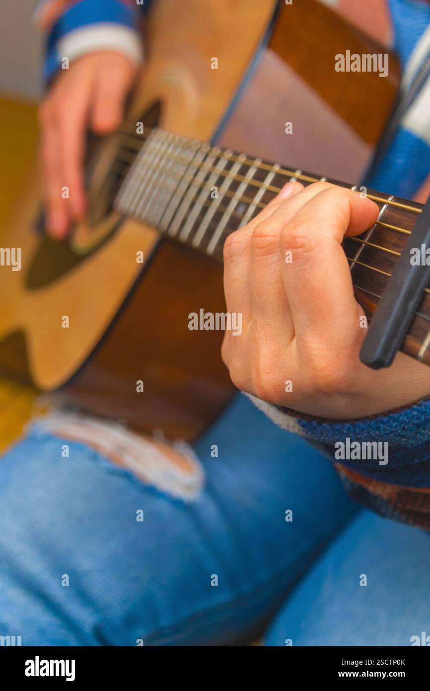 Person playing an acoustic guitar, wearing a plaid flannel and blue ...