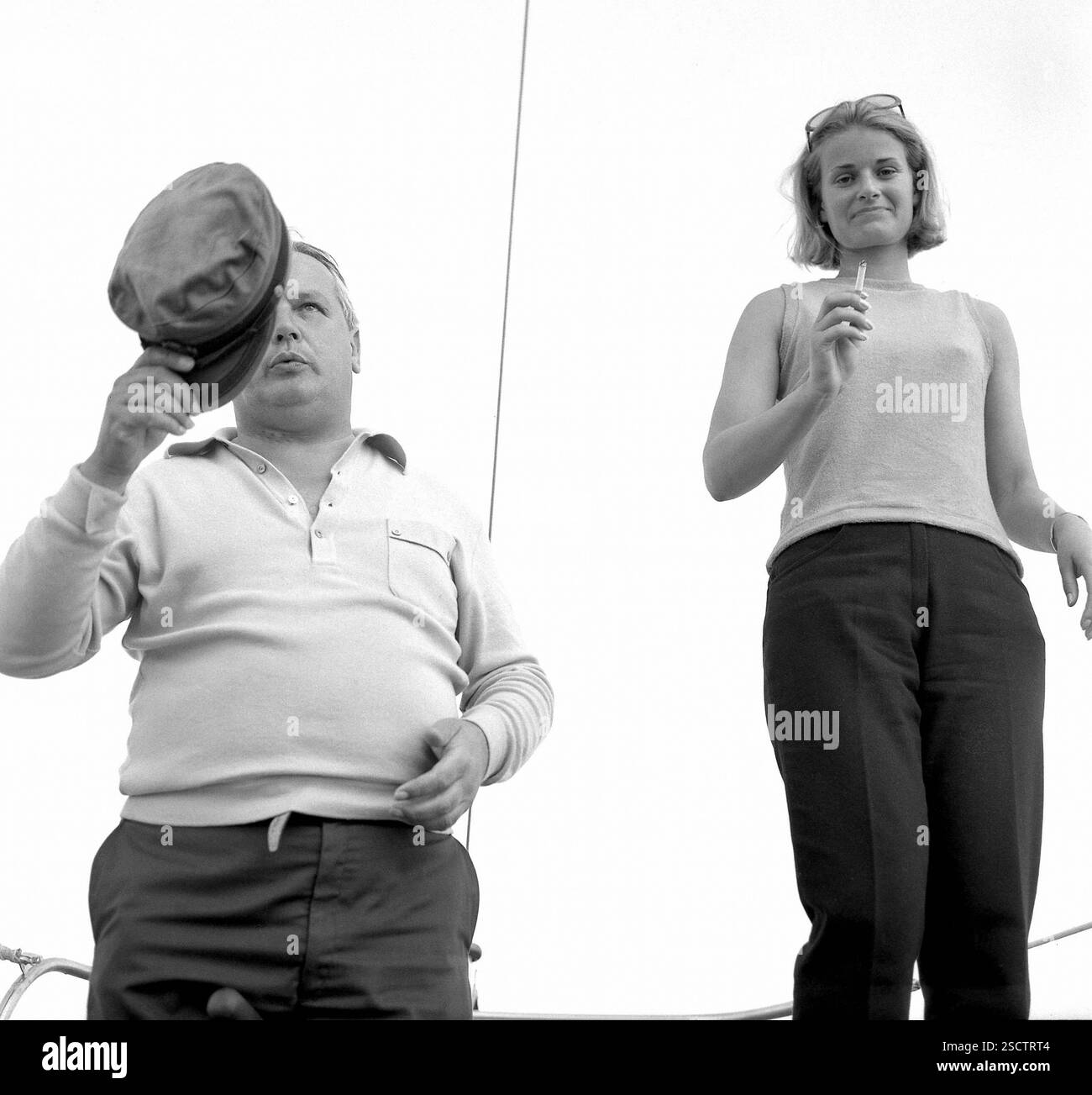 A man and a woman on a sailing boat. The woman is smoking a cigarette ...