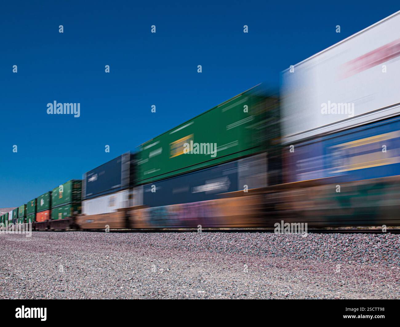 A fast moving freight train transports shipping containers quickly by ...