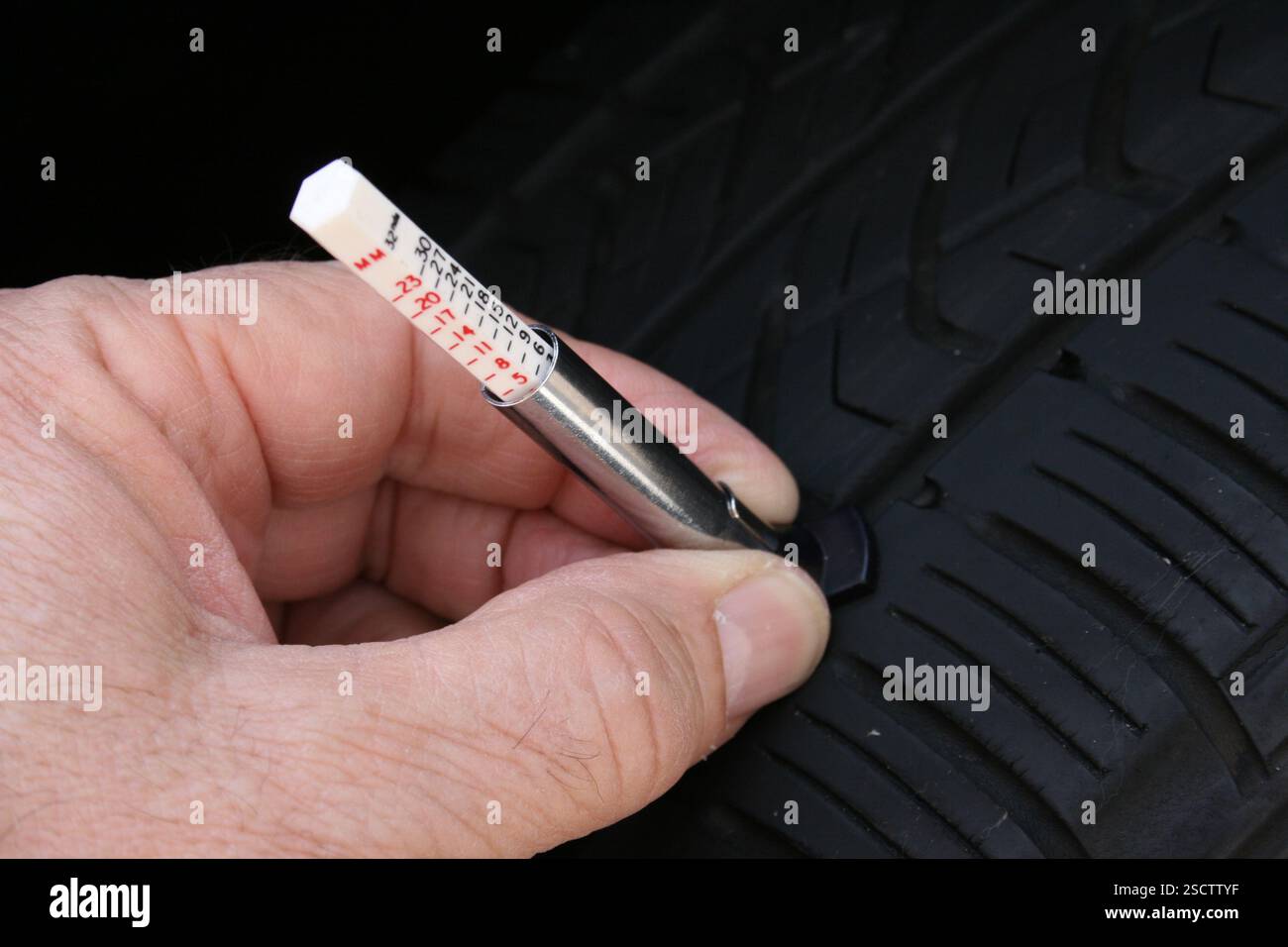 A mechanic uses a depth gauge to measure the depth of a tire tread for ... A mechanic uses a depth gauge to measure the depth of a tire tread for ...