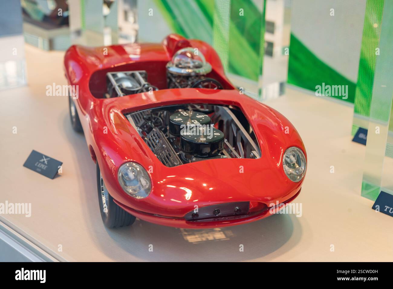 Vintage racing car model displayed at a modern exhibition in a vibrant ...