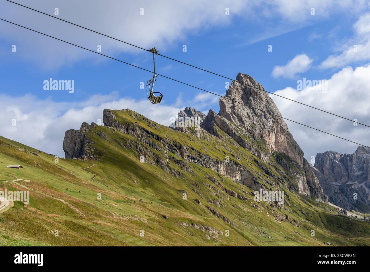 The steep cliffs of Seceda rise dramatically above rolling grassy ...