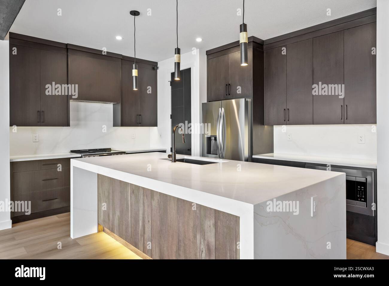A kitchen with a white countertop and brown cabinets. The countertop ...