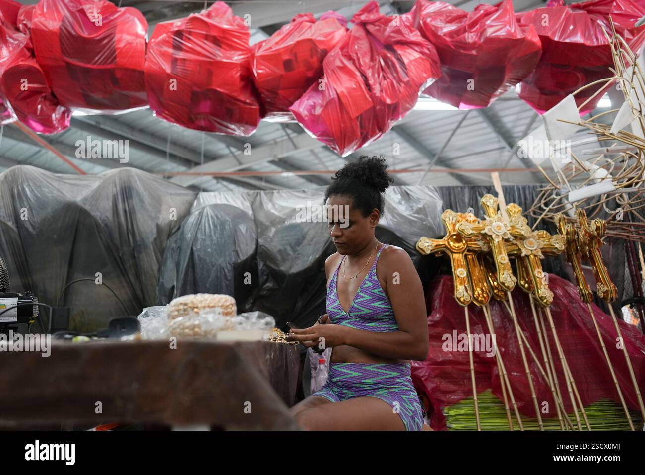 A member of the "Unidos de Padre Miguel" samba school works on costumes ...