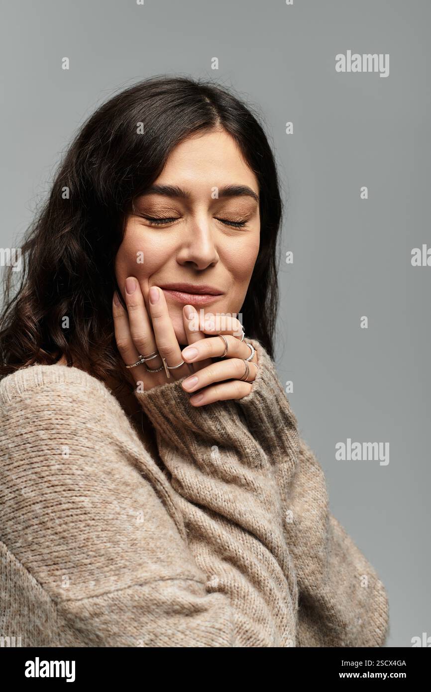 Brunette woman with closed eyes expresses joy in a serene studio ...