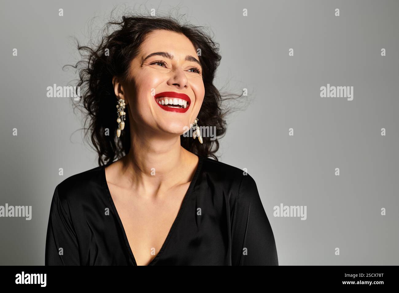 Elegant brunette woman radiating joy in a stylish studio setting with ...