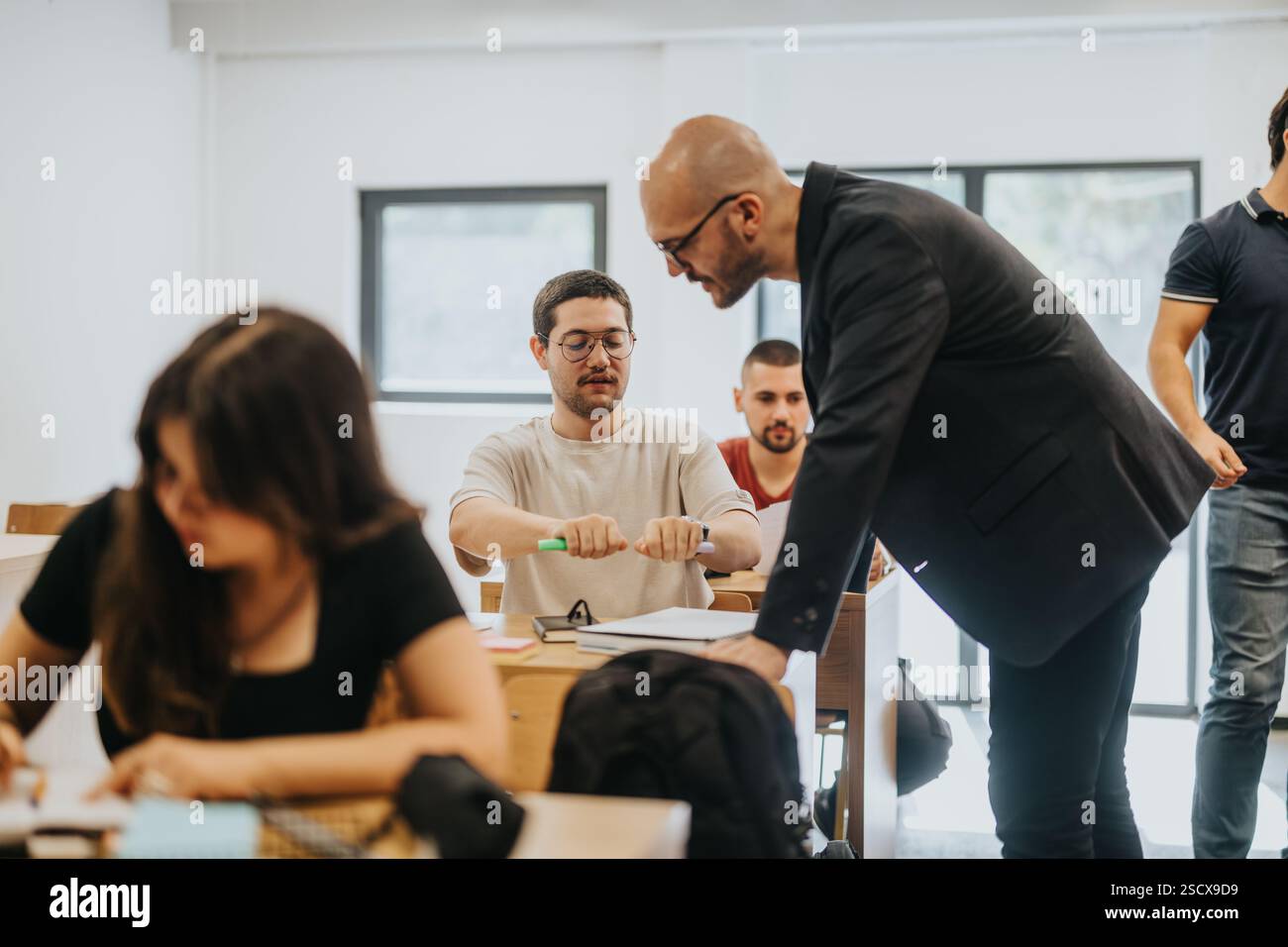 High school students engaged in a classroom setting with teacher Stock ...