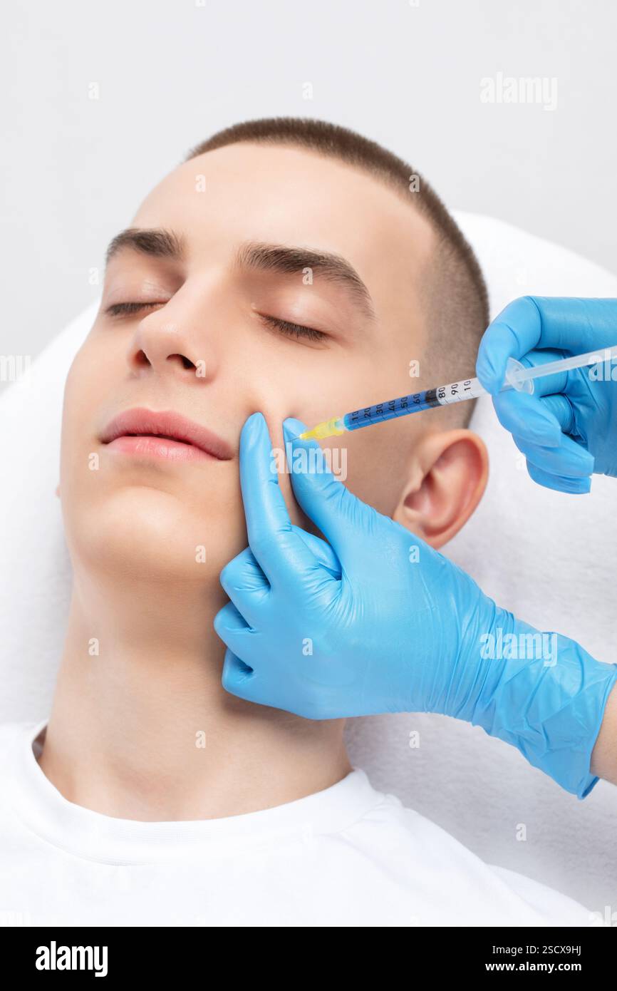 Men's cosmetology. Beautician makes a man a rejuvenation injection ...