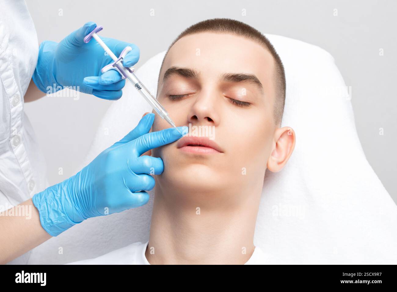 The cosmetologist makes injections for lip augmentation and anti ...