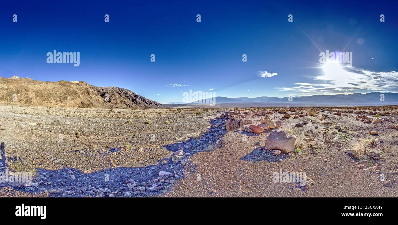 Vast desert landscape under a bright blue sky with distant mountains ...
