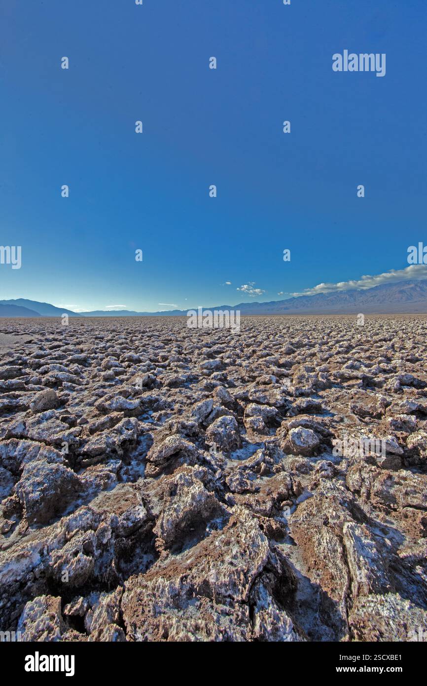 Rugged salt formations of Devils Golf Course under a bright blue sky ...
