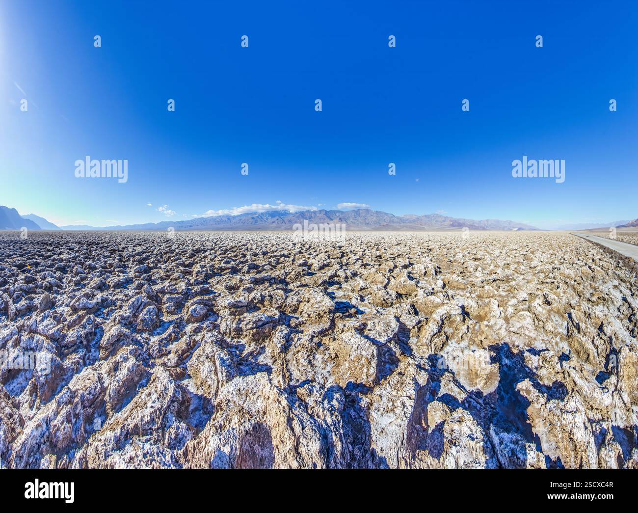 Rugged salt formations of Devils Golf Course under a bright blue sky ...