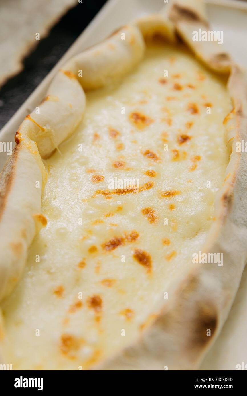 Turkish cheese pide with melted mozzarella on a plate in elegant and ...