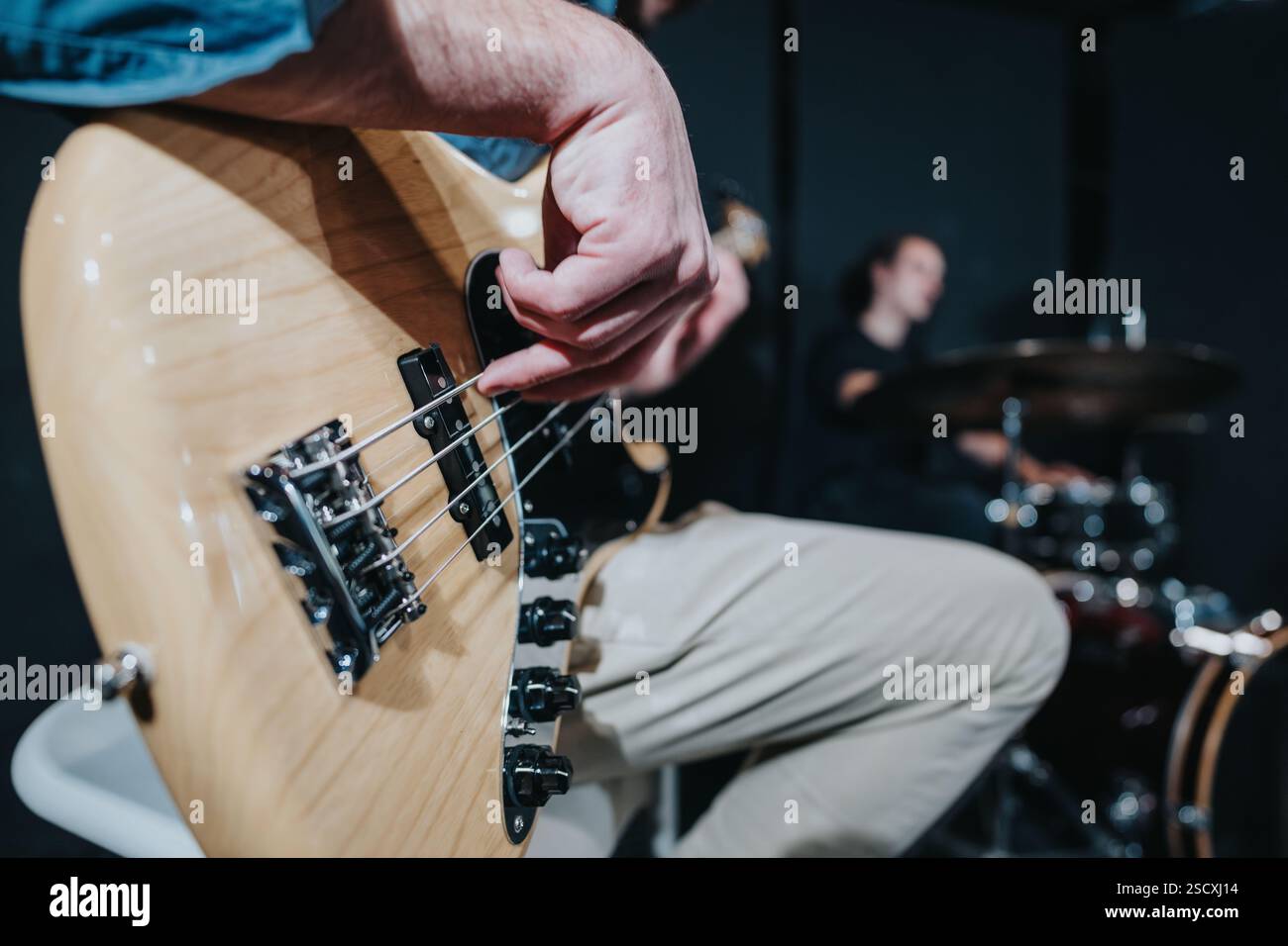 Band members practicing together, featuring a close-up of guitar ...