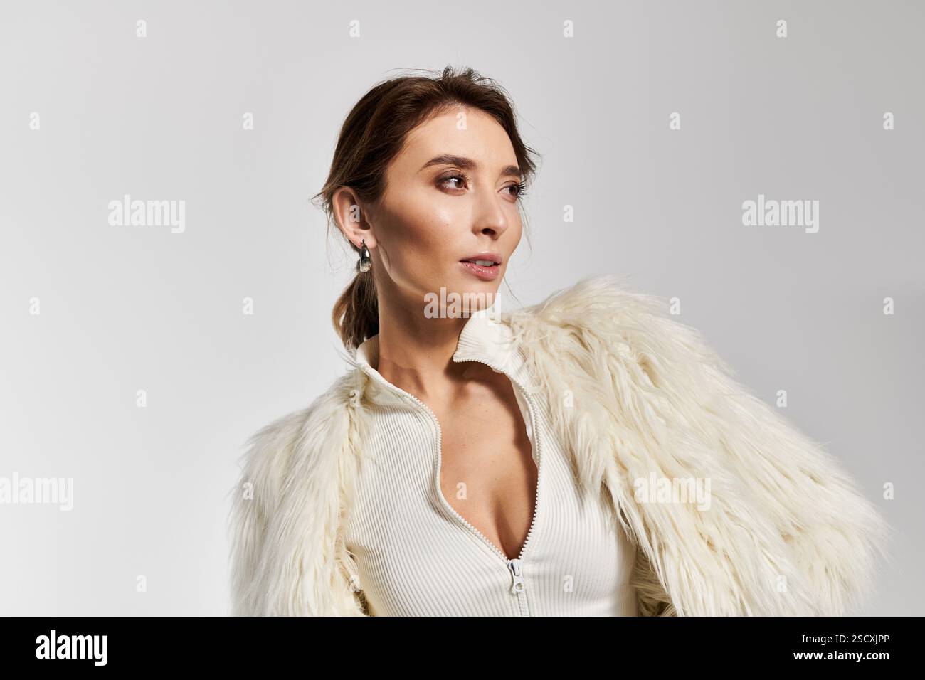 Elegant young woman showcasing chic attire style in a modern studio ...