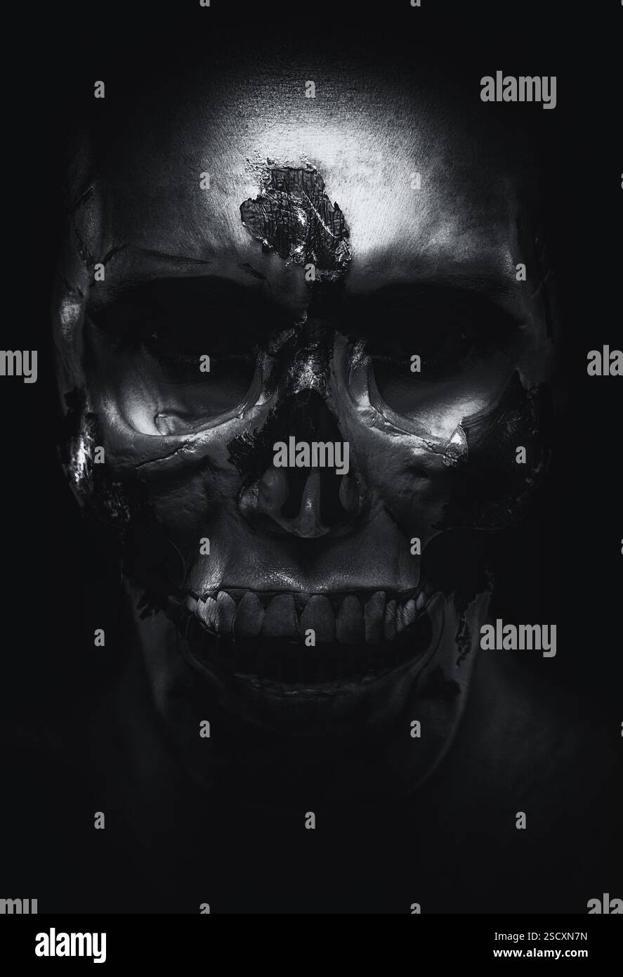 Screaming frightened girl with a mask of a human skull on her face on a ...