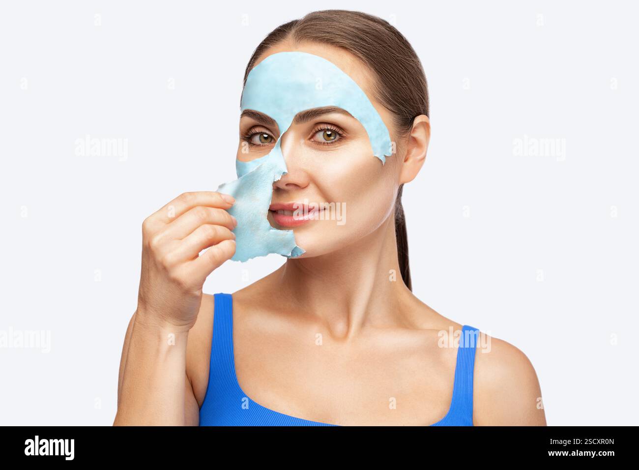 A beautician makes an alginate blue face mask for a woman's face to ...