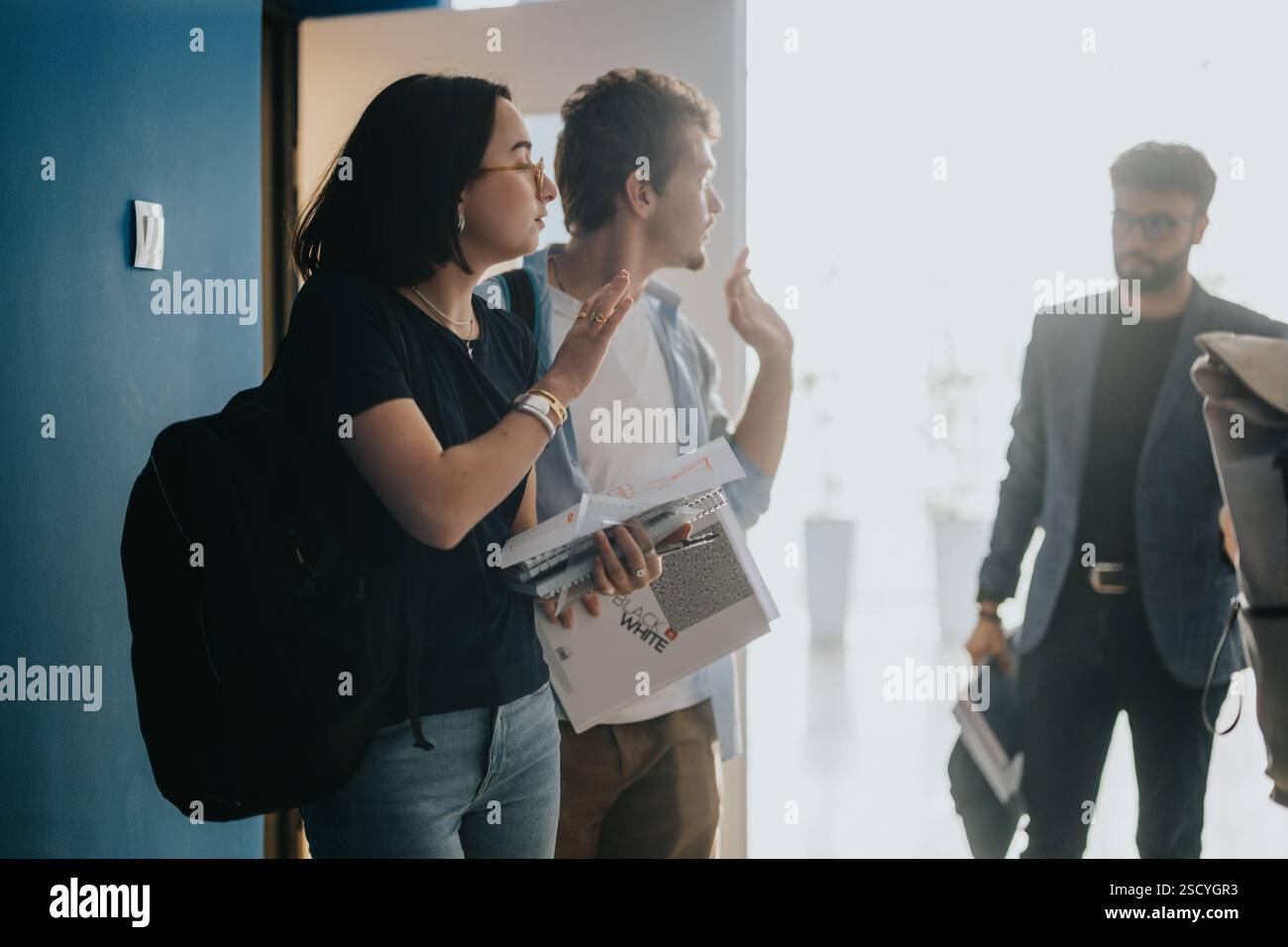 Students engaging with professor in hallway between classes Stock Photo ...