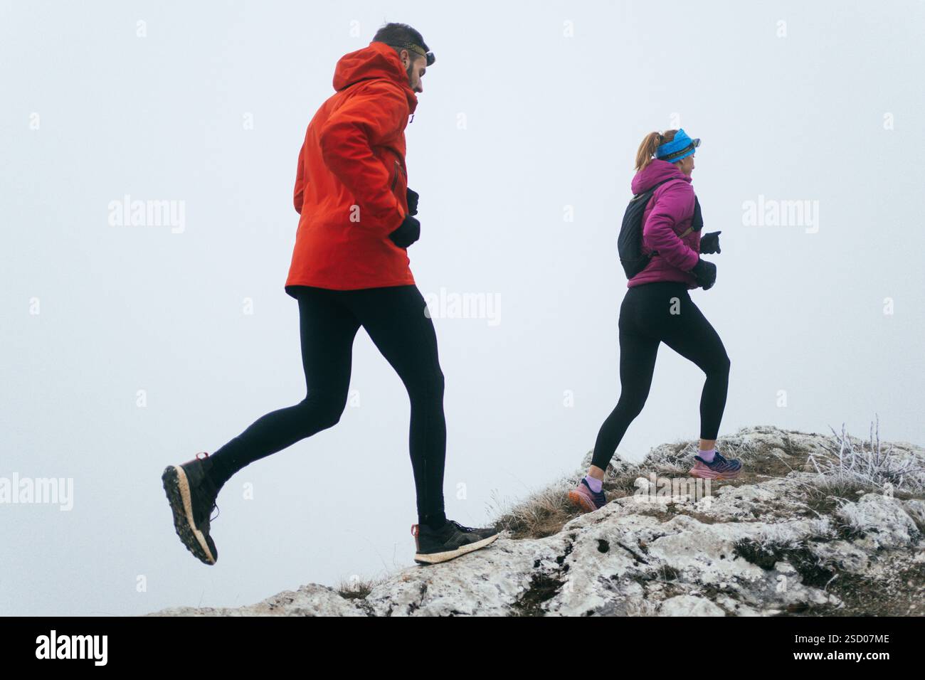 Trail running couple man and woman running on a mountain path Stock ...