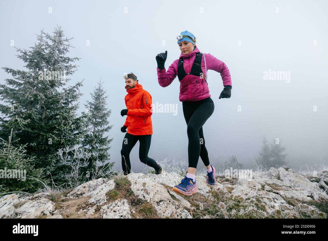 Trail running couple man and woman running on a mountain path Stock ...